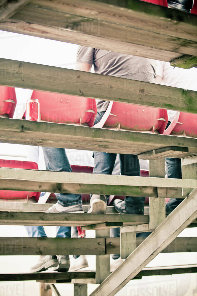 Low section of people sitting on bleachers - Stock Photo - Dissolve