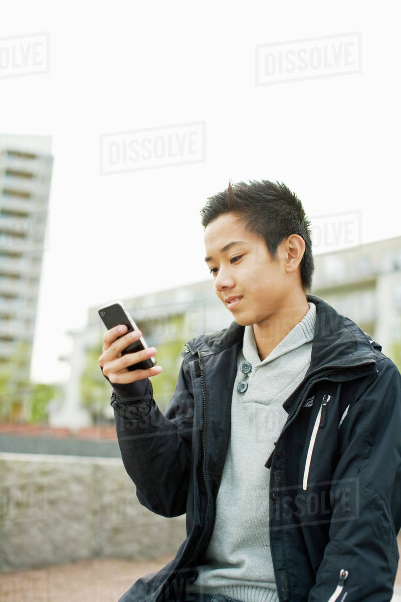 Teenage boy using smart phone - Royalty-free Stock Photo | Dissolve