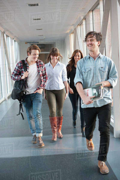 Happy young university student walking in corridor - Stock Photo - Dissolve