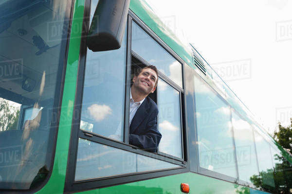 Happy mid adult bus driver looking through bus window - Stock Photo ...