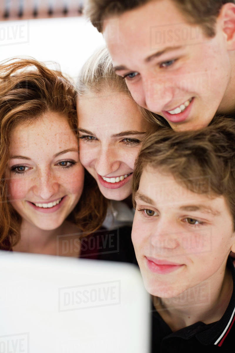 Happy young friends looking at laptop screen - Royalty-free Stock Photo ...