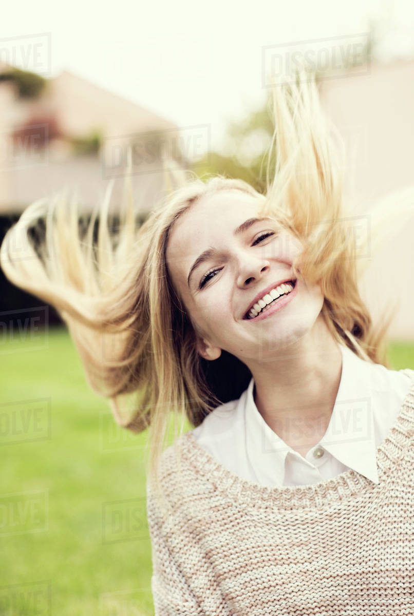 Portrait of happy young girl tossing hair - Stock Photo - Dissolve