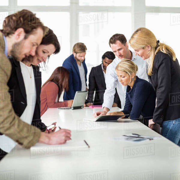 Group of business people working together at desk in office - Royalty ...