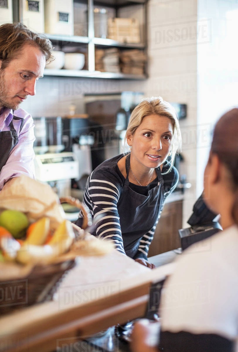 Female owner attending customer at counter in restaurant - Royalty-free ...