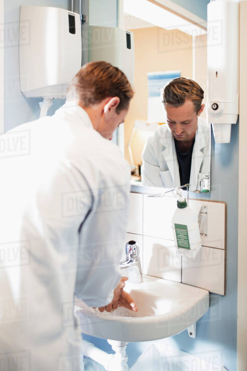 Rear view of male doctor washing hands in bathroom - Royalty-free Stock ...