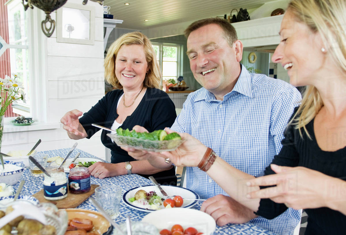 Three people at dinner - Royalty-free Stock Photo | Dissolve