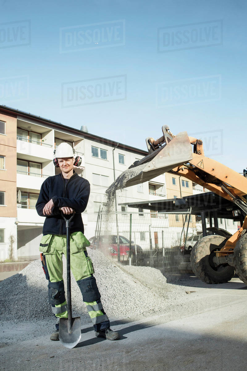 Full length portrait of confident construction worker with shovel ...