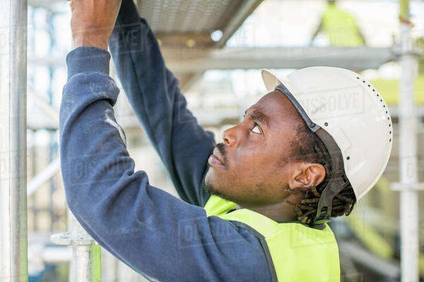 Side view of worker working at construction site - Royalty-free Stock ...