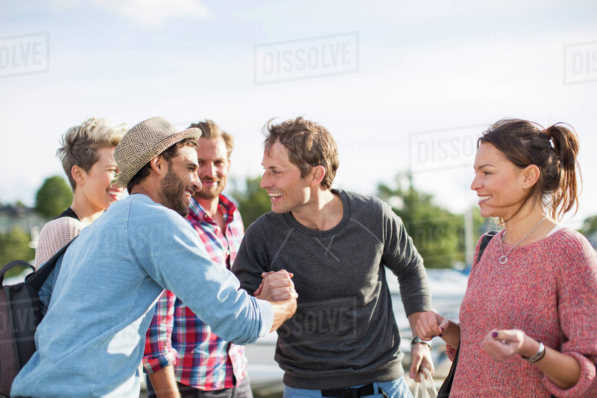 Happy friends greeting each other against sky - Royalty-free Stock ...