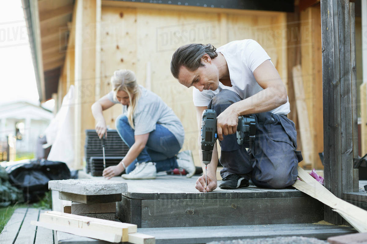 Couple working outside house during home improvement - Royalty-free ...