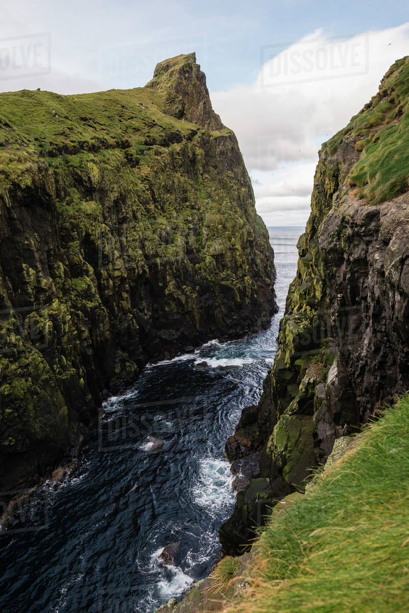 River flowing between huge cliffs at Faroe islands - Stock Photo - Dissolve