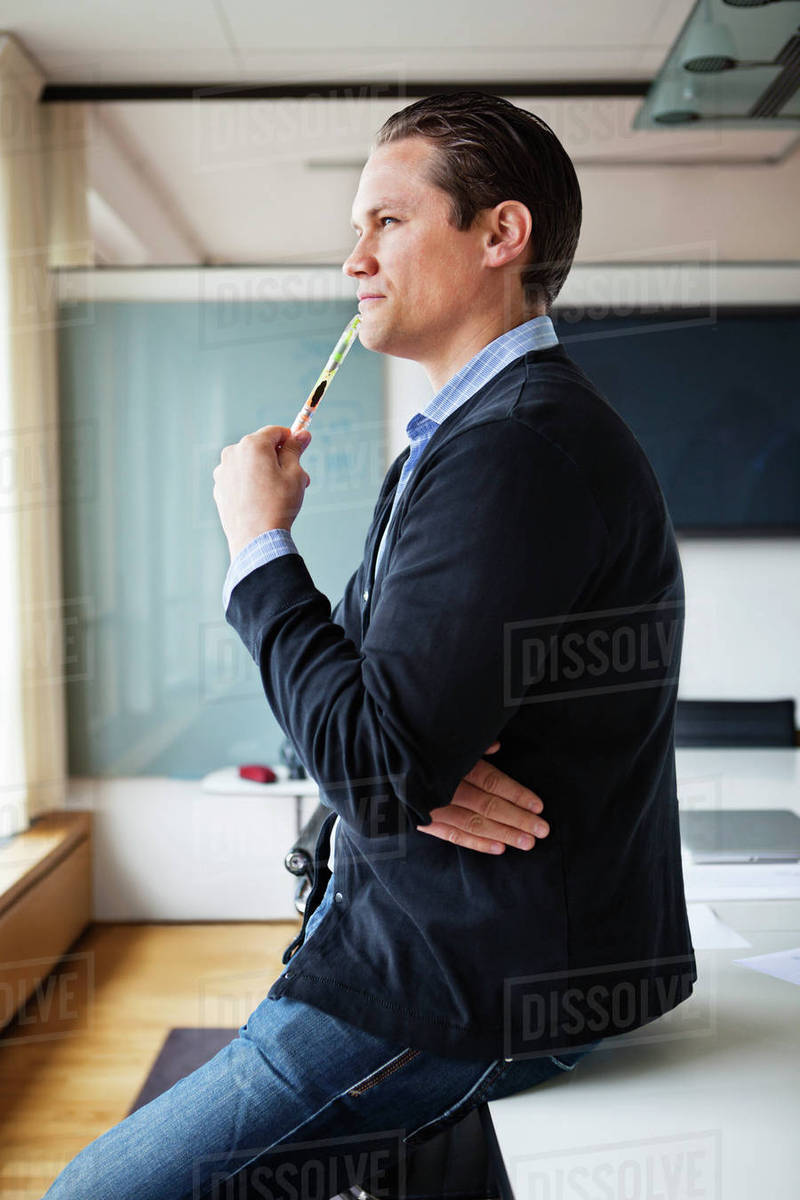 Side view of mid adult man thinking - Royalty-free Stock Photo | Dissolve