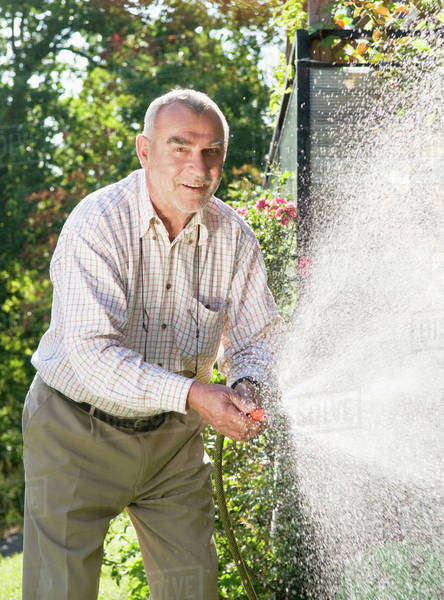 Man with water hose - Royalty-free Stock Photo | Dissolve