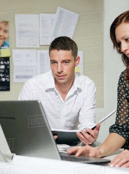 Two people at desk look at computer - Royalty-free Stock Photo | Dissolve