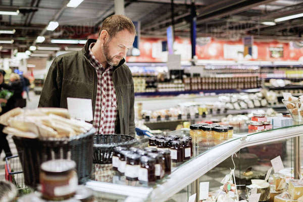 Thoughtful male customer shopping at supermarket - Royalty-free Stock ...