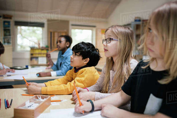 Concentrated students sitting at desk in classroom - Royalty-free Stock ...