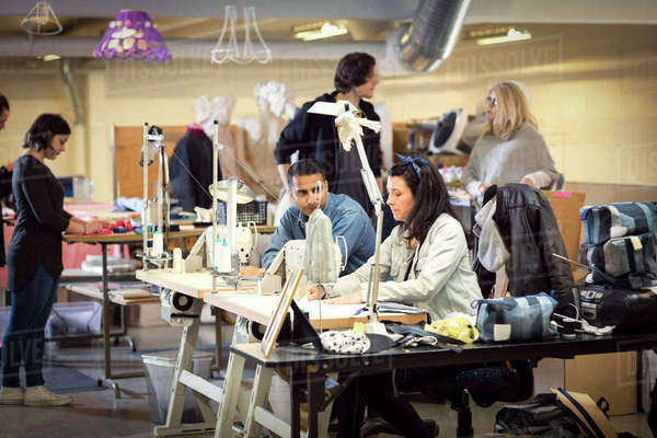 Volunteers discussing while working at workshop - Royalty-free Stock ...