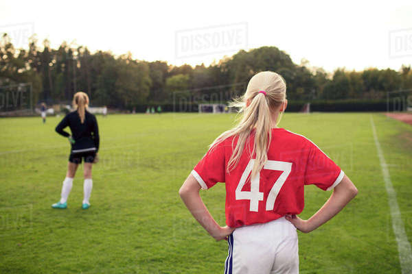Rear view of girl standing on soccer field - Royalty-free Stock Photo ...