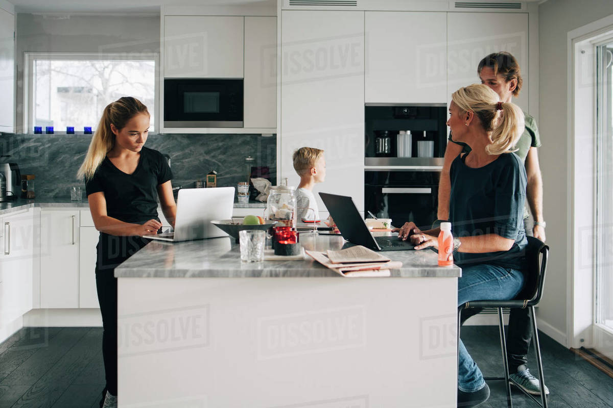 Family in kitchen using technologies at home - Royalty-free Stock Photo ...