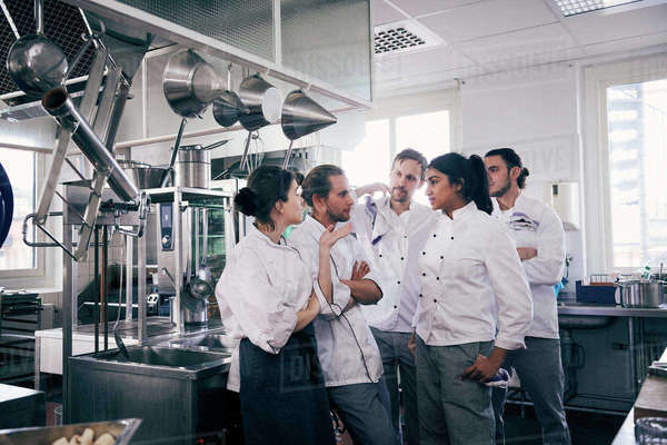 Chefs communicating in commercial kitchen - Stock Photo - Dissolve