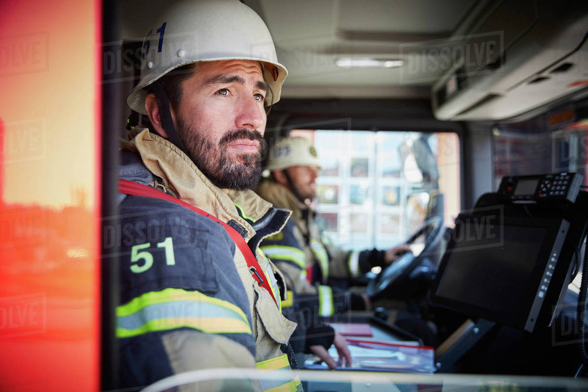Firefighter looking through window while sitting in fire truck ...