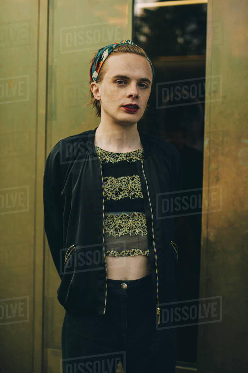 Portrait of man with hands behind back standing against wall - Royalty ...