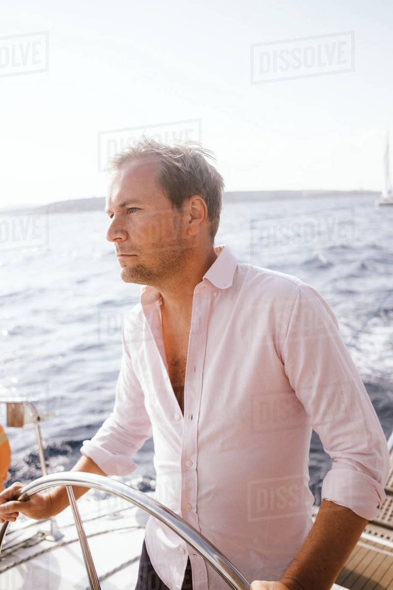 Confident sailor sailing catamaran on sea against sky - Stock Photo ...