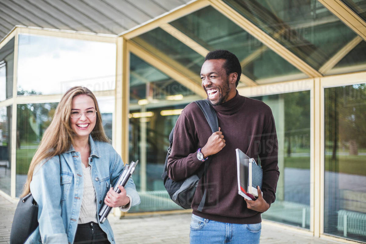 Happy male and female students at university - Stock Photo - Dissolve