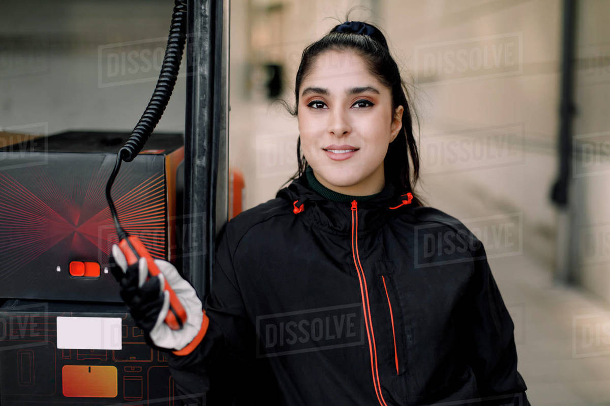 Portrait of confident young delivery woman by truck - Stock Photo ...