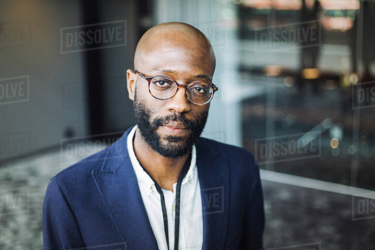 Portrait of male entrepreneur standing in office - Stock Photo - Dissolve