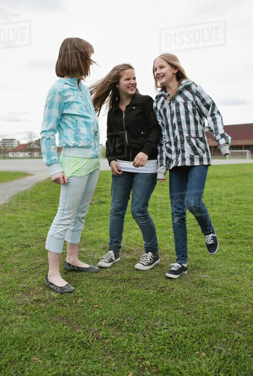 Three friends playing on lawn - Royalty-free Stock Photo | Dissolve