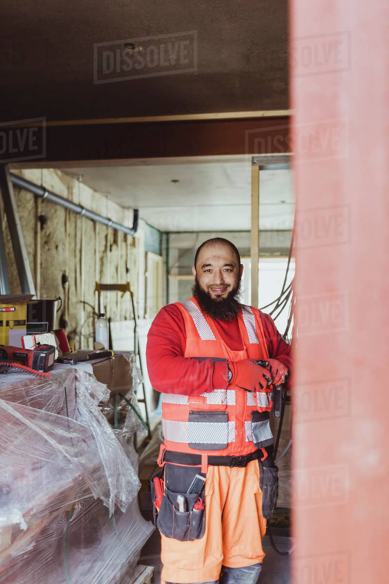 Smiling bearded construction worker working at site - Stock Photo ...
