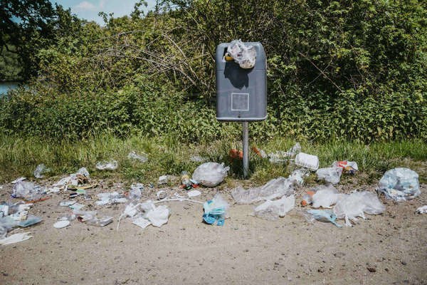 Garbage bin littered with plastic wastes around in park - Royalty-free ...