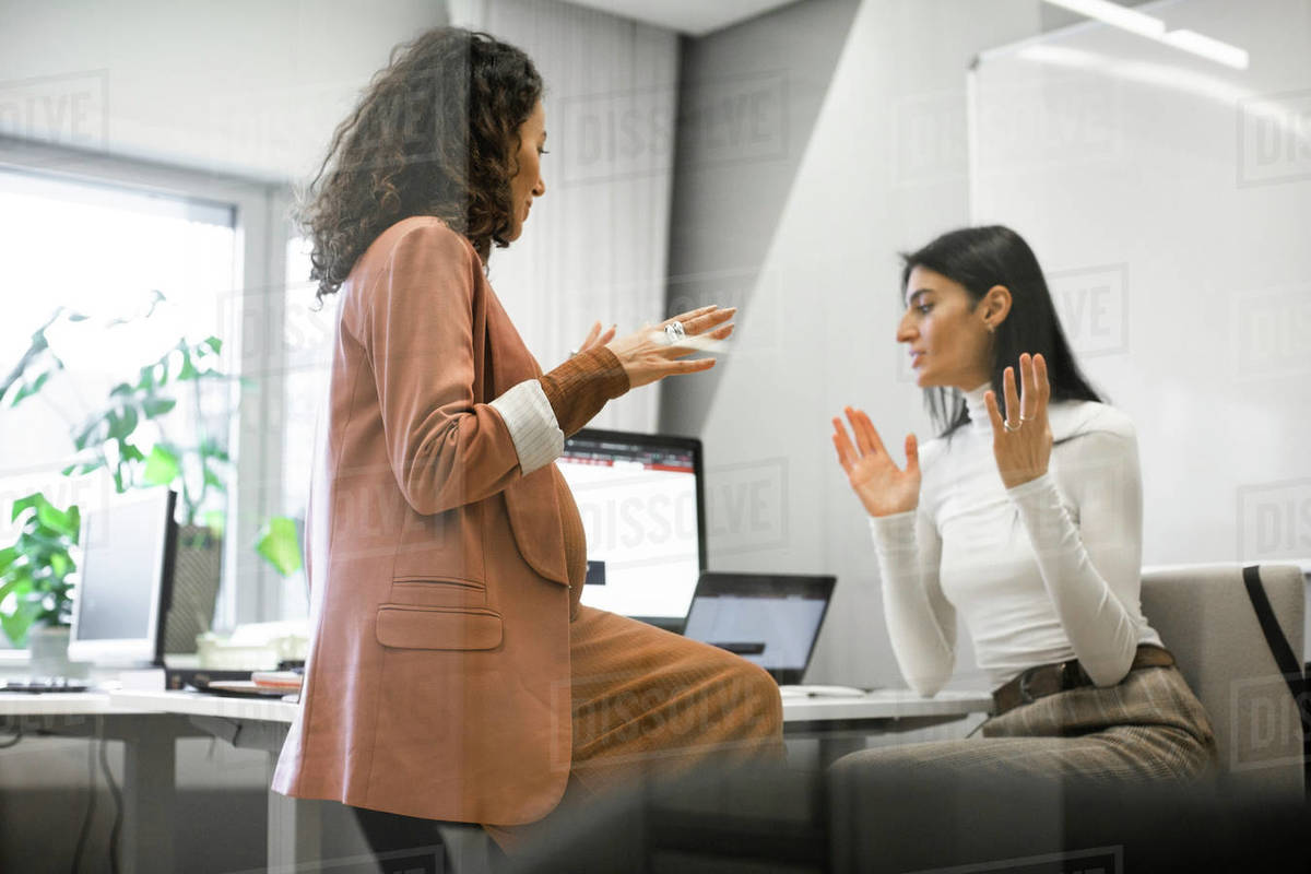 Female boss discussing with colleague over computer in office - Stock ...