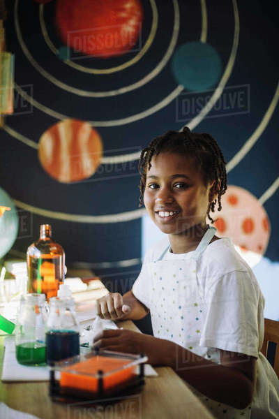 Portrait of smiling girl doing scientific experiment at home - Royalty ...