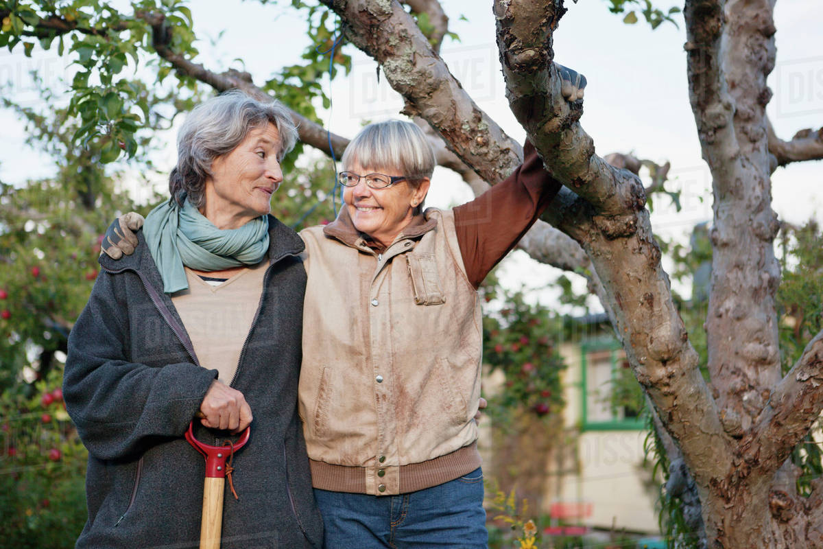 Two women standing beside tree - Royalty-free Stock Photo | Dissolve
