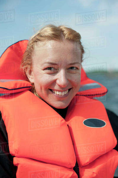 Happy woman wearing life jacket - Stock Photo - Dissolve