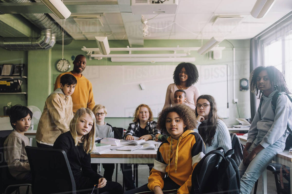 Portrait of diverse students with teachers in classroom at school ...