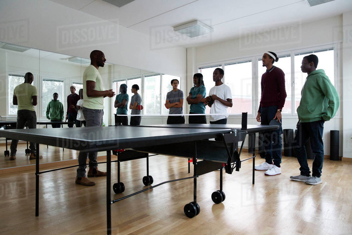 Coach listening to students during training session in games room ...