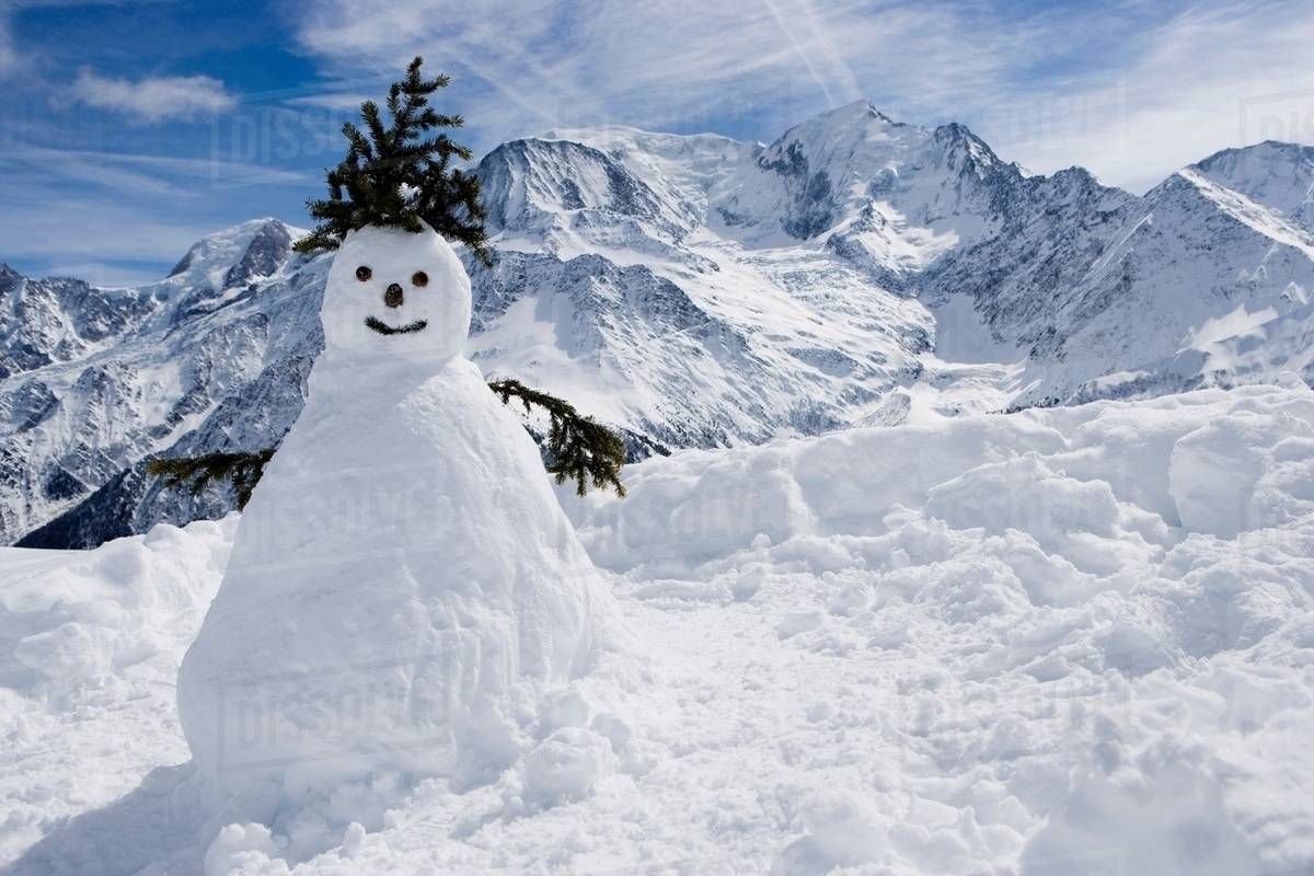 A snowman with mountains behind - Stock Photo - Dissolve