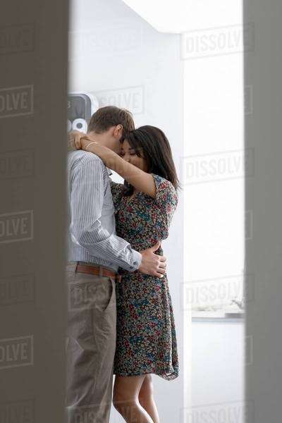 Man and woman cuddling in office - Royalty-free Stock Photo | Dissolve