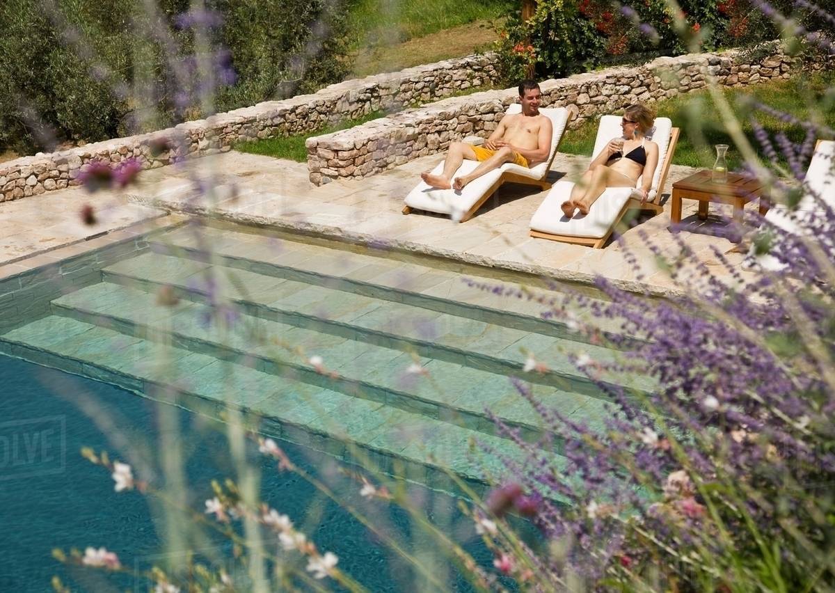 Man and woman relaxing by the pool - Royalty-free Stock Photo | Dissolve