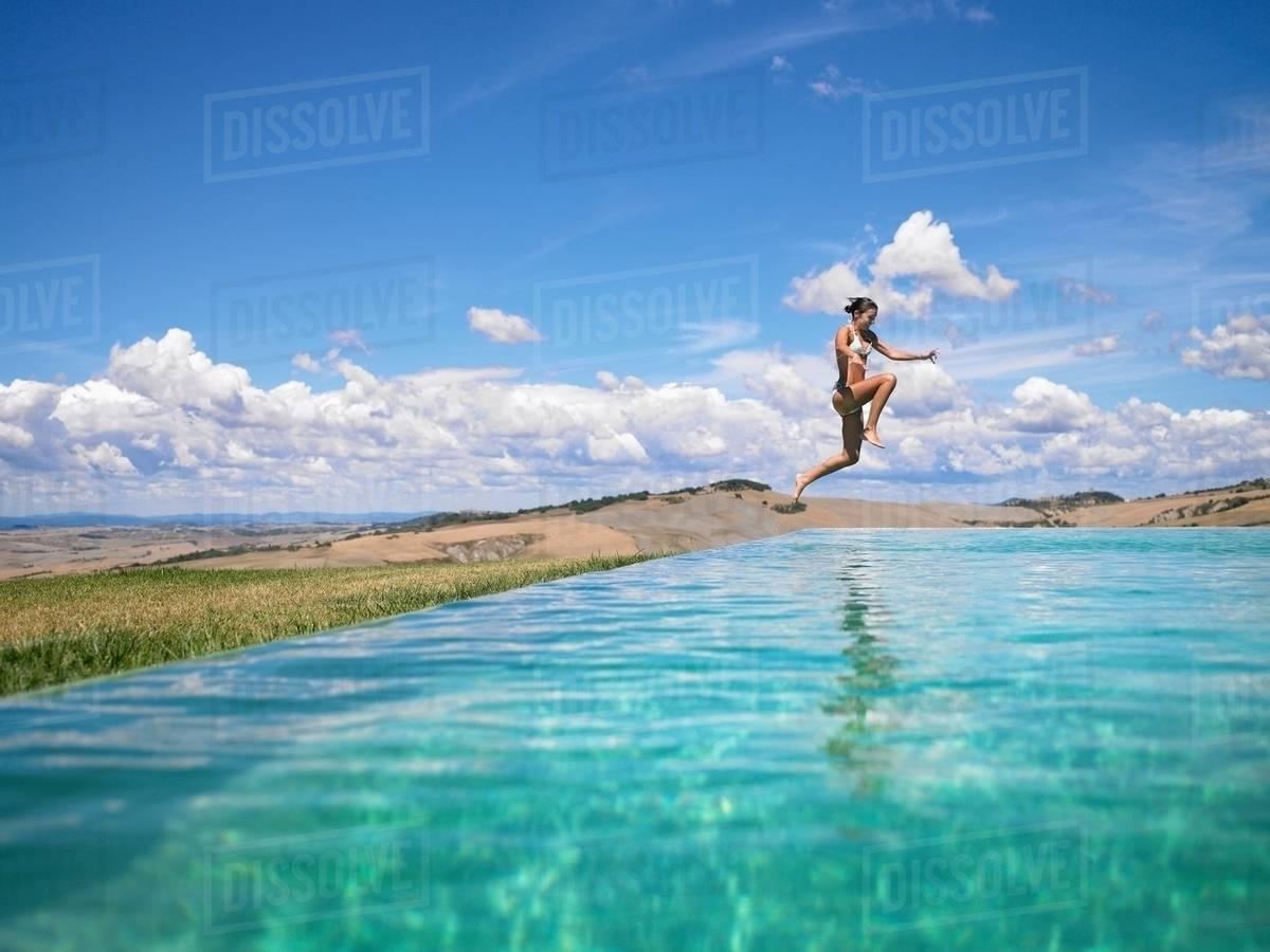 Woman jumping in swimming pool - Royalty-free Stock Photo | Dissolve