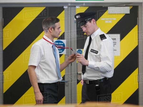 Security guard checking security tag - Stock Photo - Dissolve