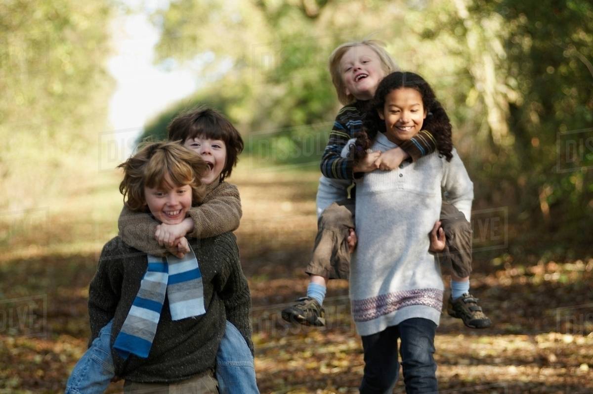 Kids in piggyback races on country lane - Stock Photo - Dissolve
