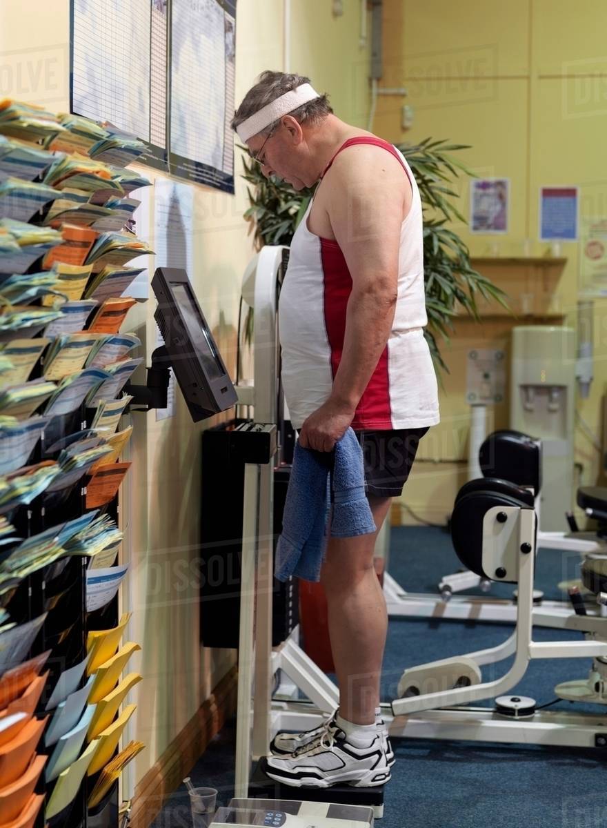Senior man on scales at gym - Royalty-free Stock Photo | Dissolve