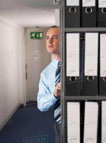 Office worker hiding behind files - Royalty-free Stock Photo | Dissolve