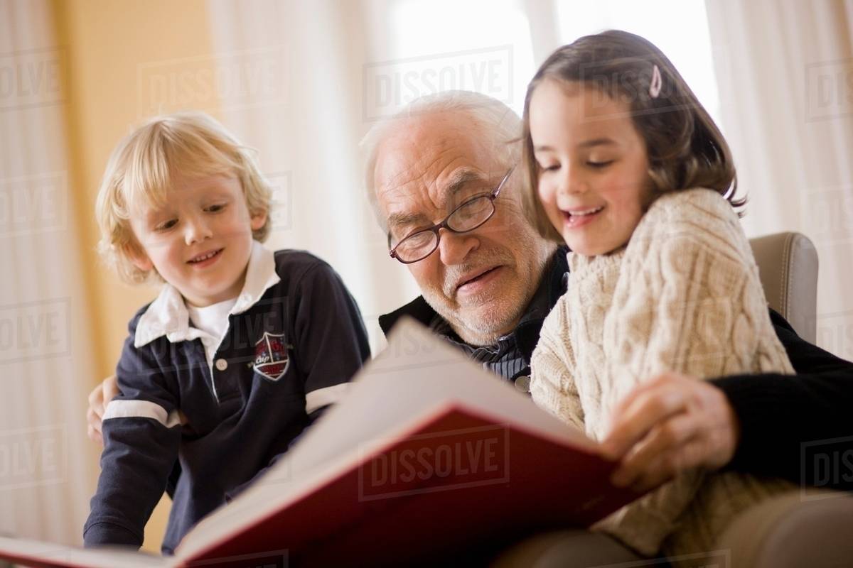 Old man reading book to children - Royalty-free Stock Photo | Dissolve