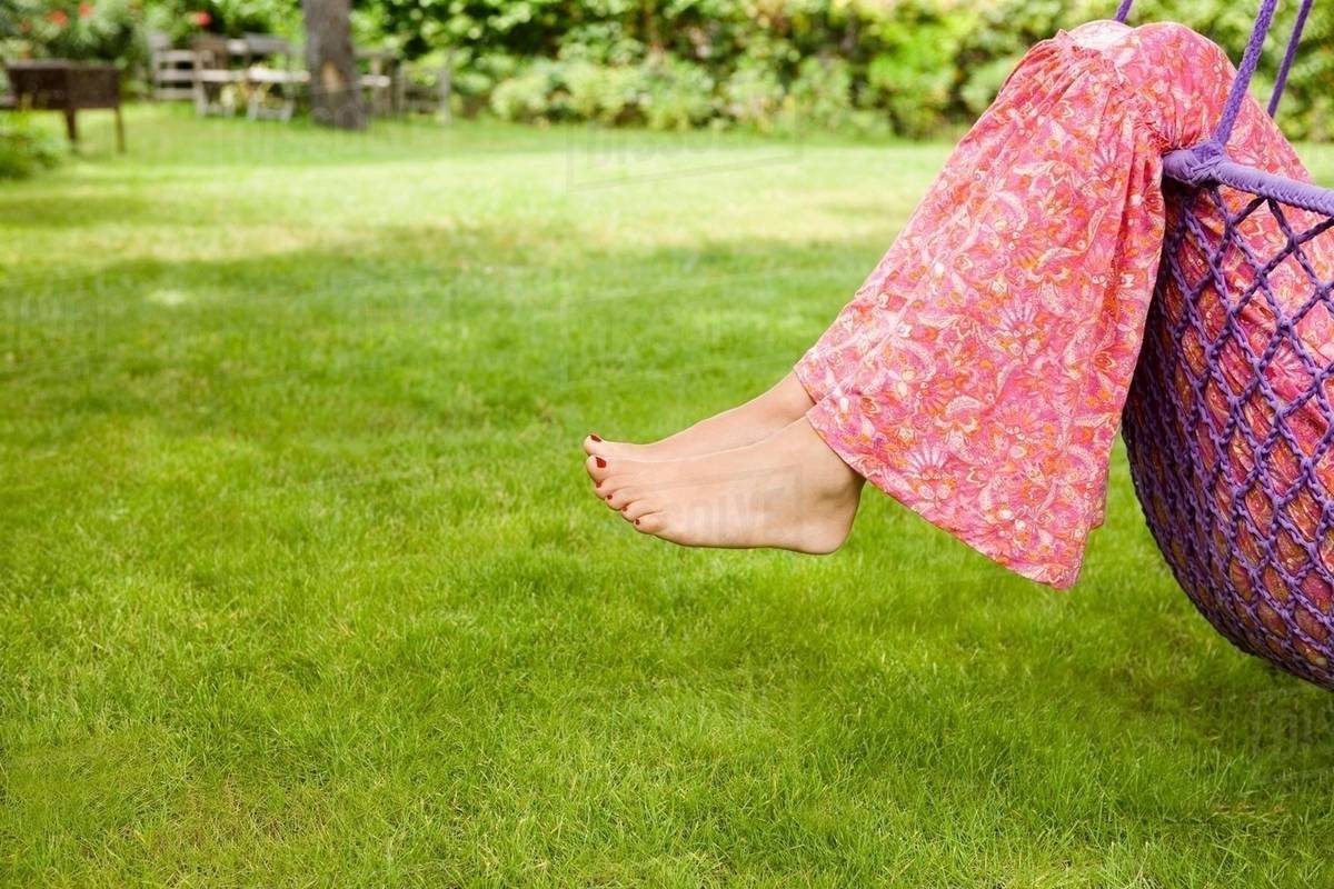 Woman's feet hanging out of a swing - Royalty-free Stock Photo | Dissolve