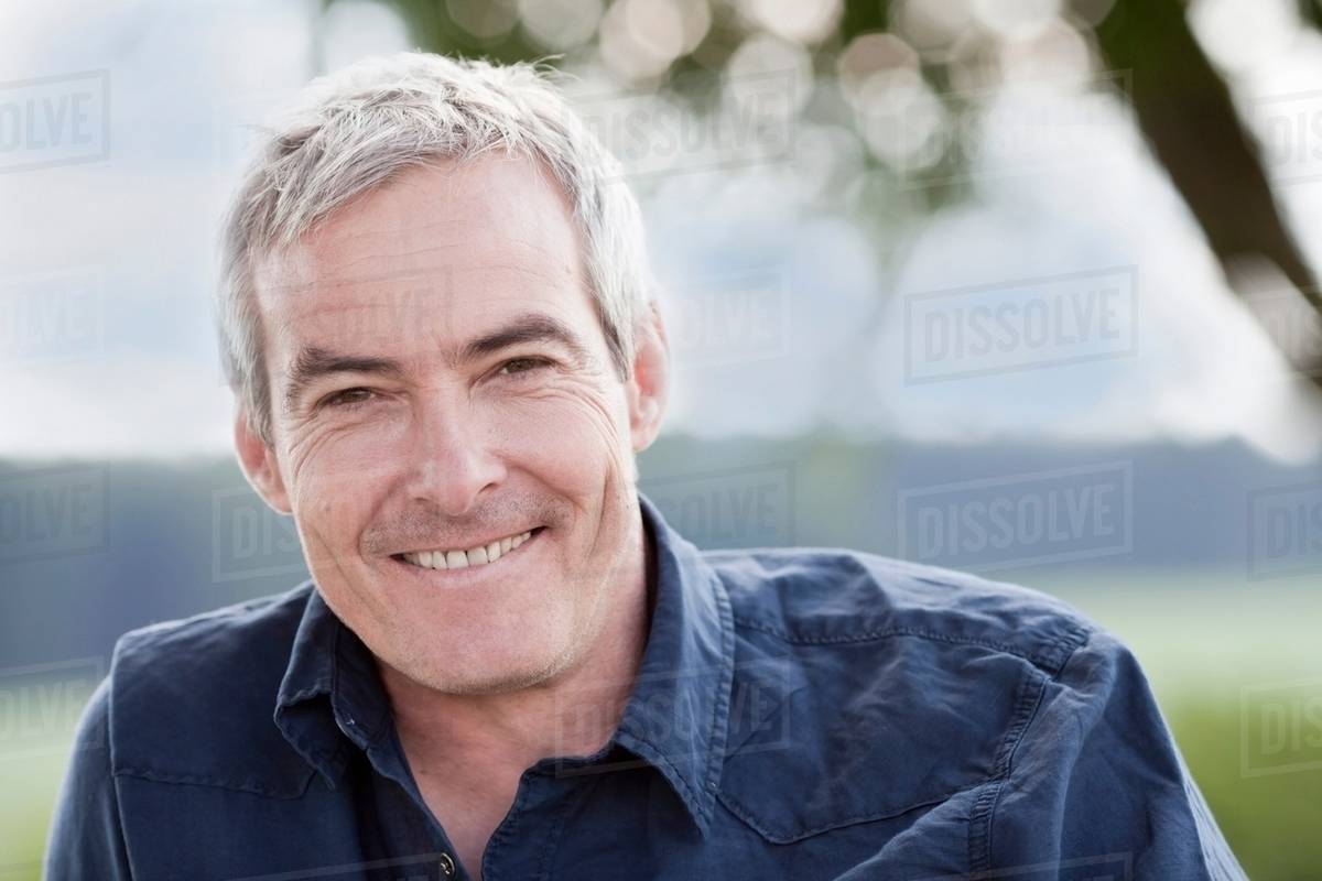 Man sitting smiling at viewer - Stock Photo - Dissolve